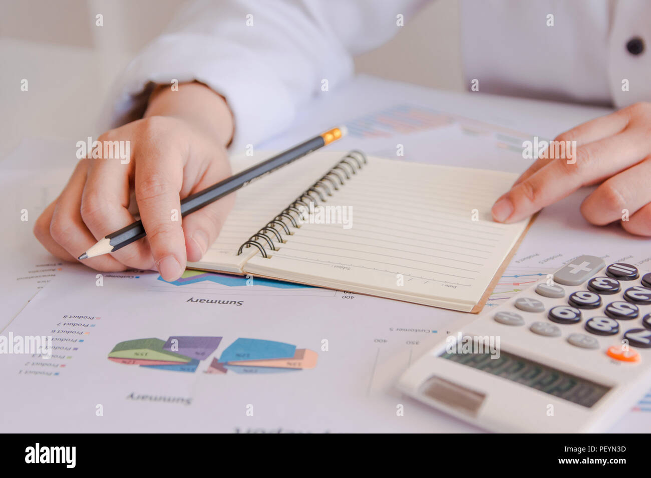 Close up woman hand using calculator and writing make note with ...