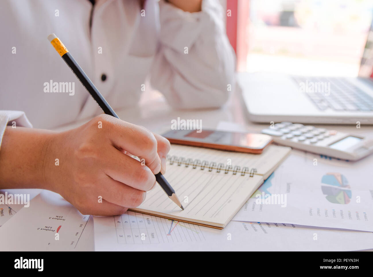 Close up woman hand using calculator and writing make note with ...