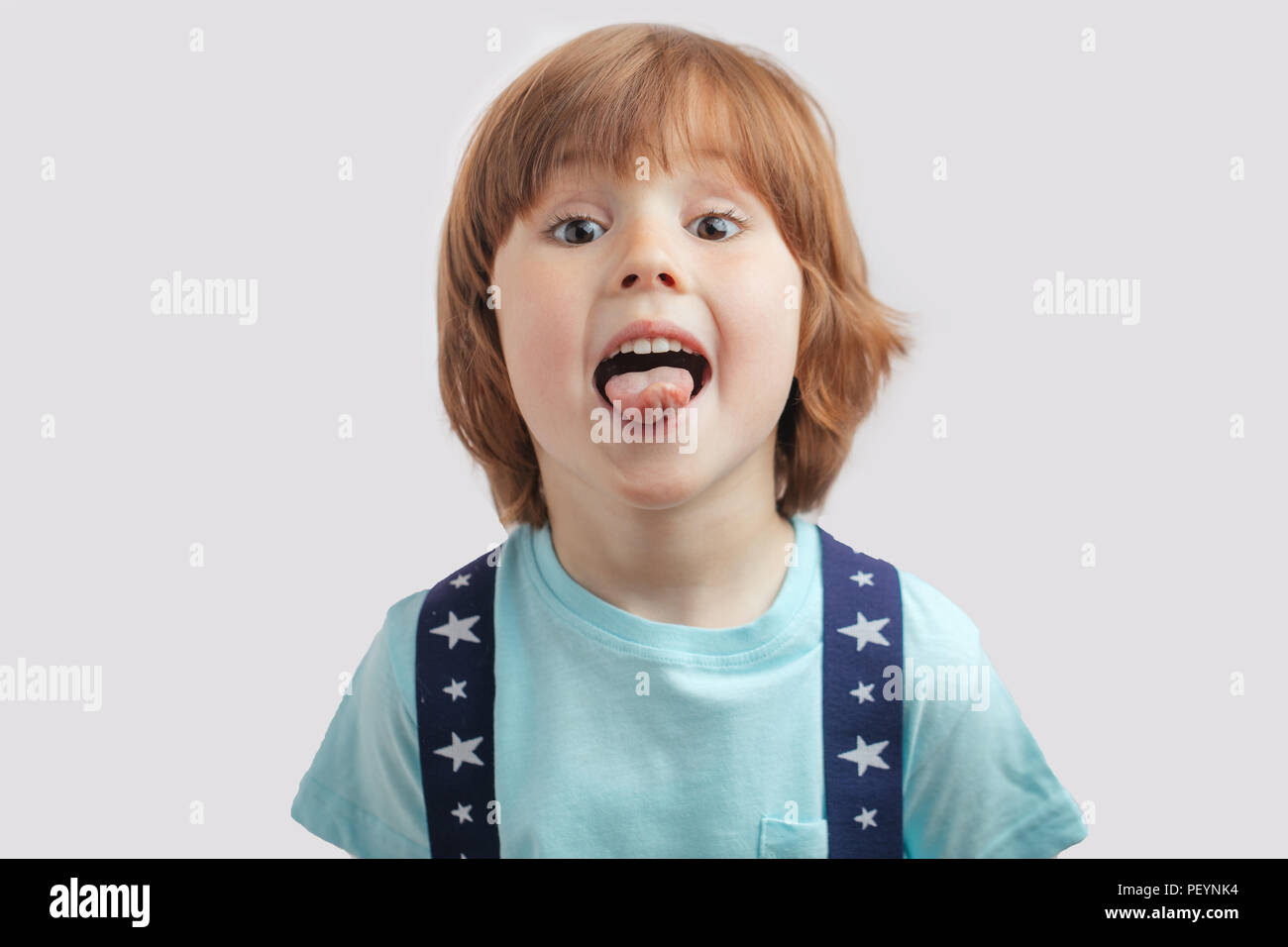 ginger boy is showing his tongue.bully, kid is teasing somebody ...