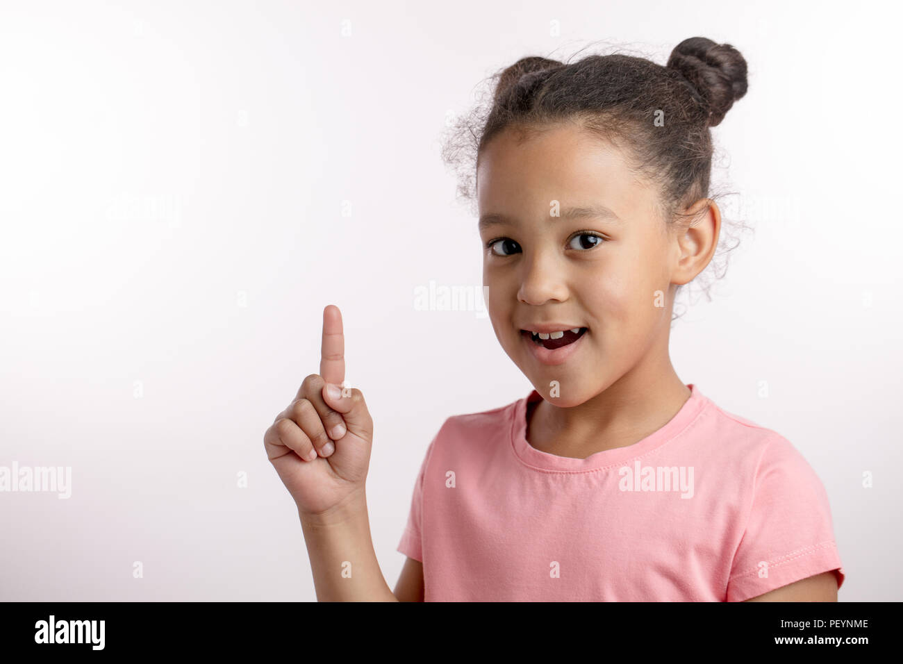 clever girl raising her finger up.posotive kid is pointing at the copy ...