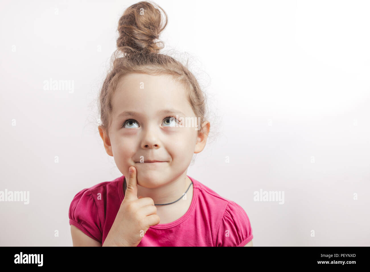 pensive cunning girl looking up and thinking about something. little ...