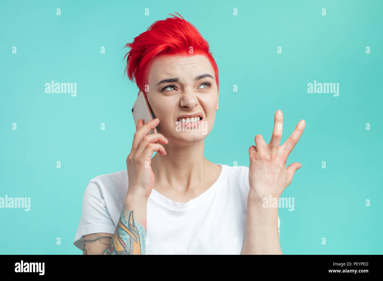 emotional frustrated angry girl with short pink hair is talking on the ...