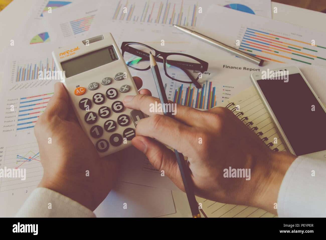 Man hand using a financial calculator and Financial data analyzing on ...