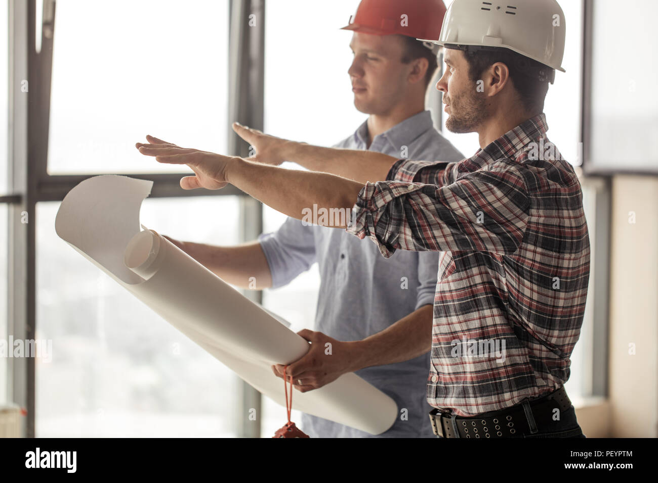 architect is pointing at building place to the customer. side view ...