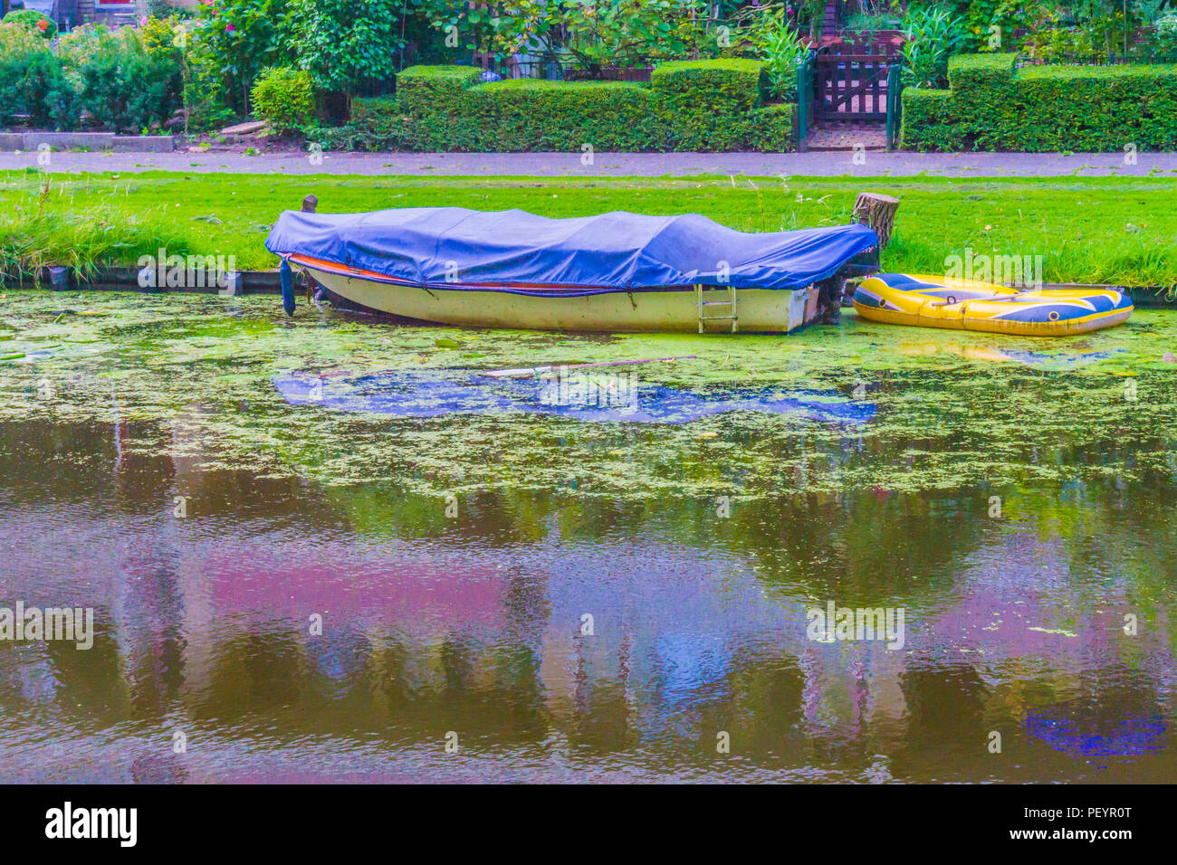 covered up boat with canvas in a river landscape Stock Photo - Alamy