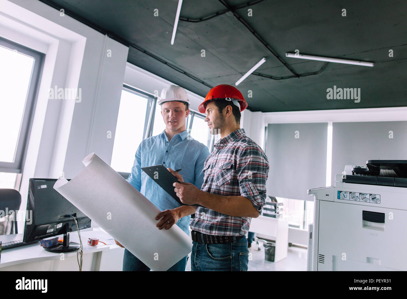 engineers are monitoring the building project in the modern office with ...