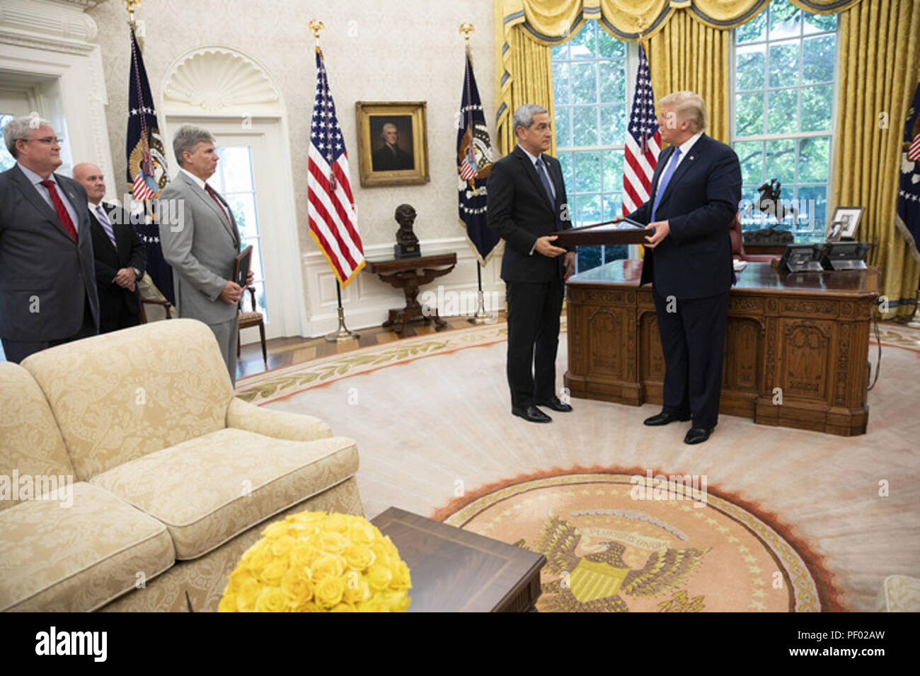 President Donald J. Trump is presented a U.S. flag by Kelly McKeague ...