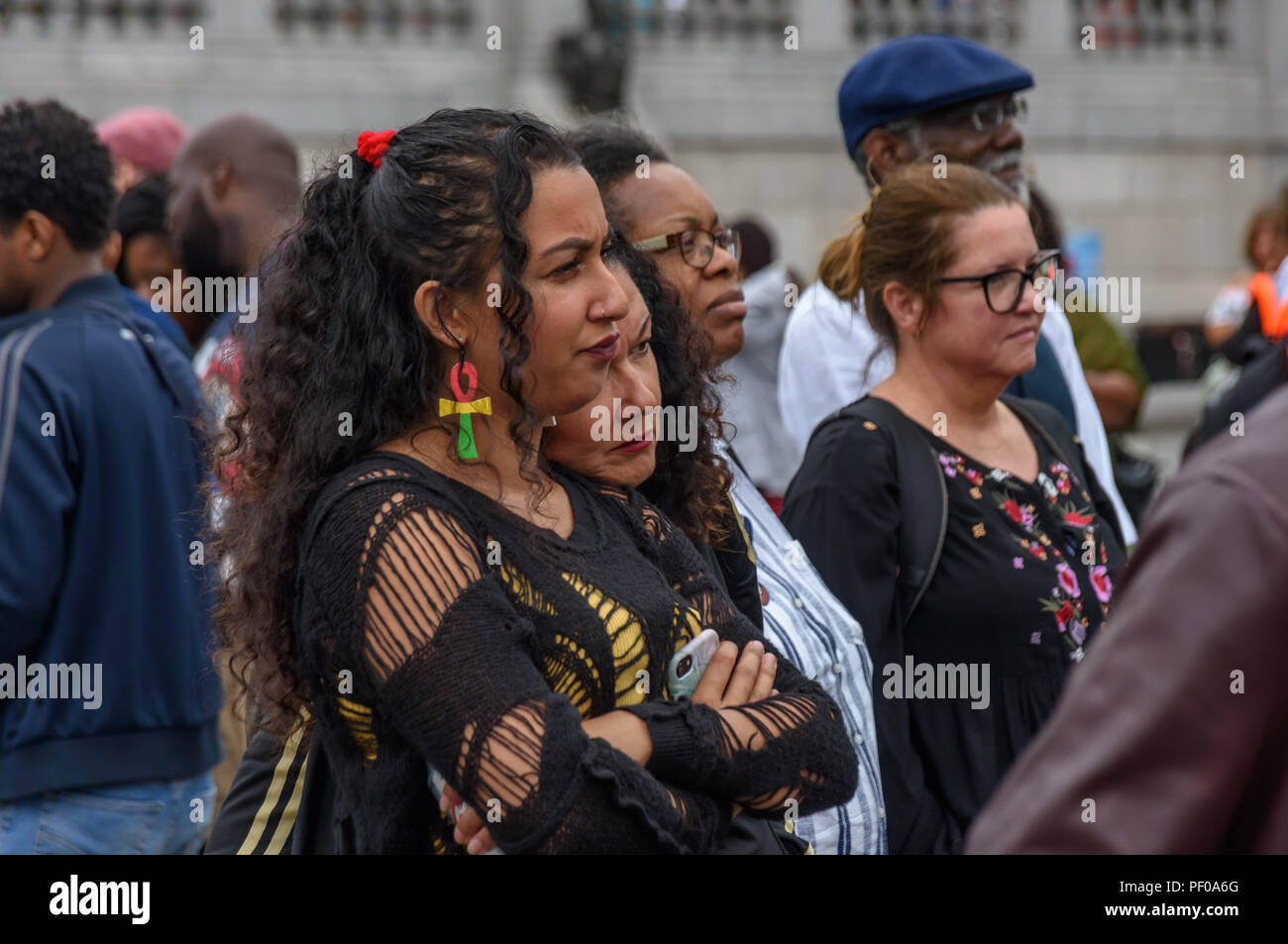 London, UK. 18th August 2018. A woman in the crowd wears Rasta ankh ear ...