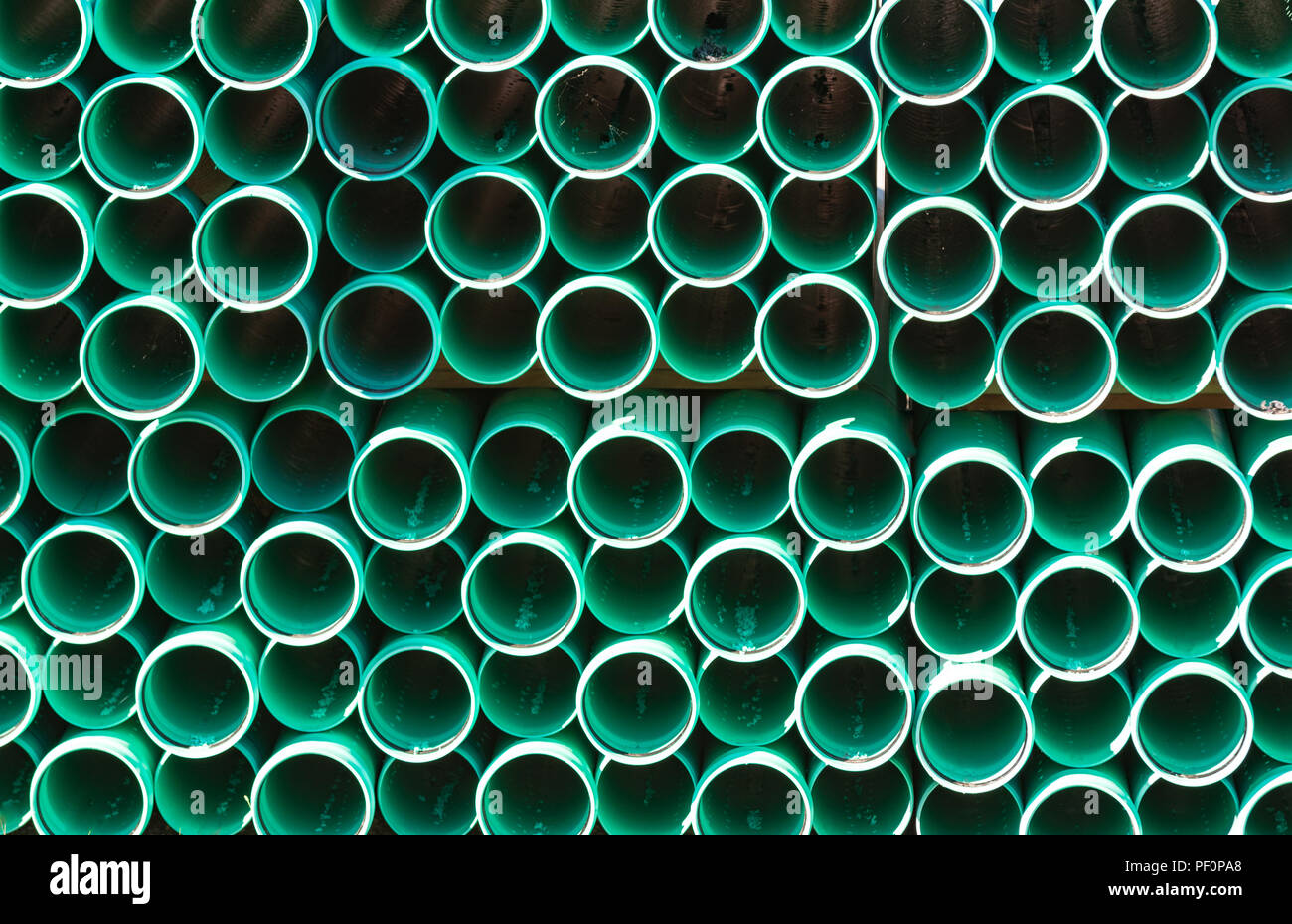 PVC conduit pipes stacked with darkened centers on edge Stock Photo - Alamy