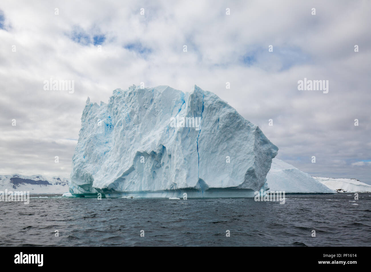icecaps in the Antarctica with iceberg in the ocean swimming around and ...