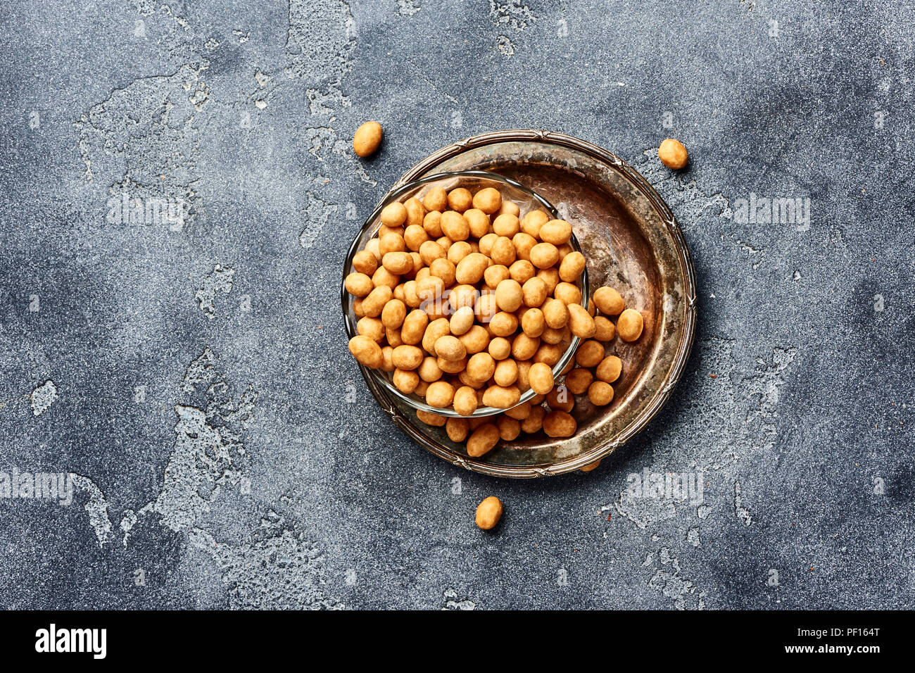 Spicy coated fried peanuts on gray background. Top view of snacks and ...