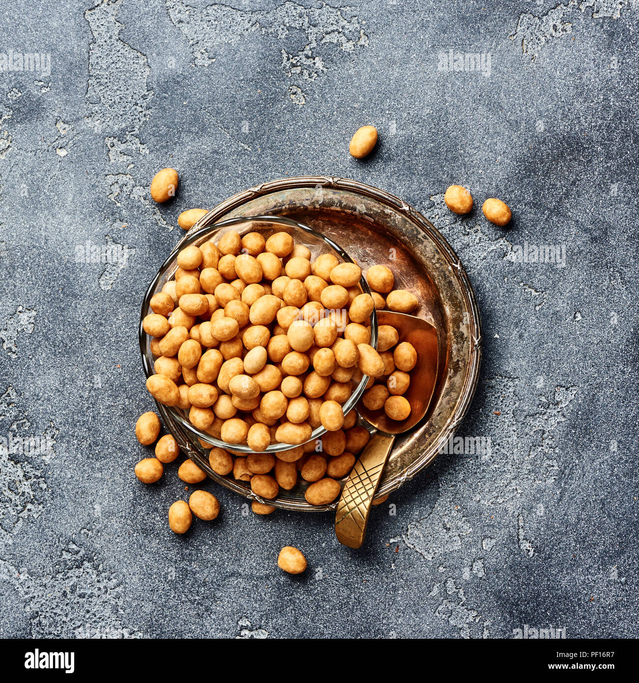 Spicy coated fried peanuts on gray background. Top view of snacks and ...