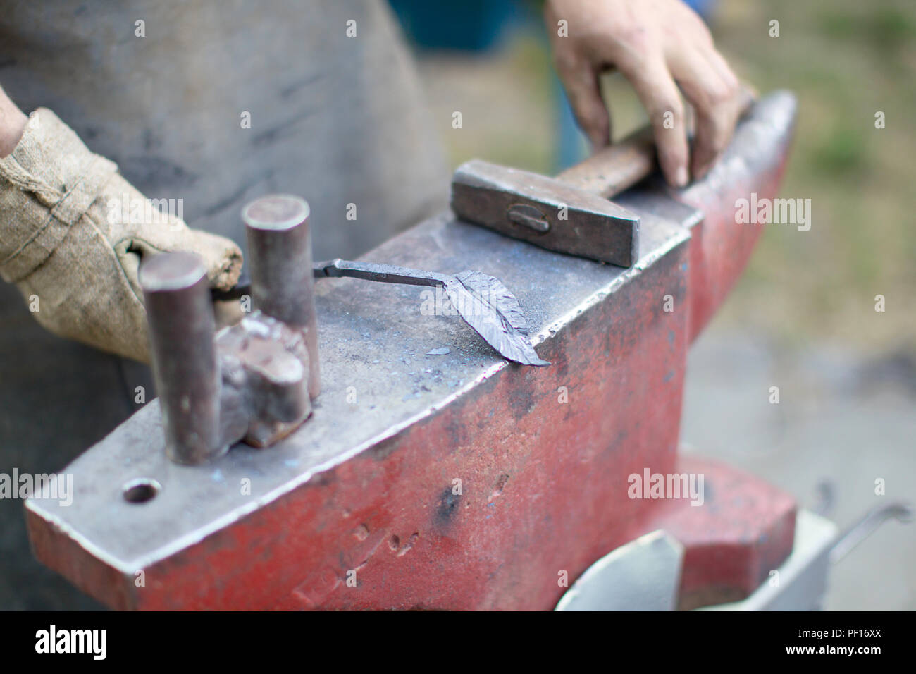 Forging iron. Working hands with a hammer forge iron Stock Photo - Alamy
