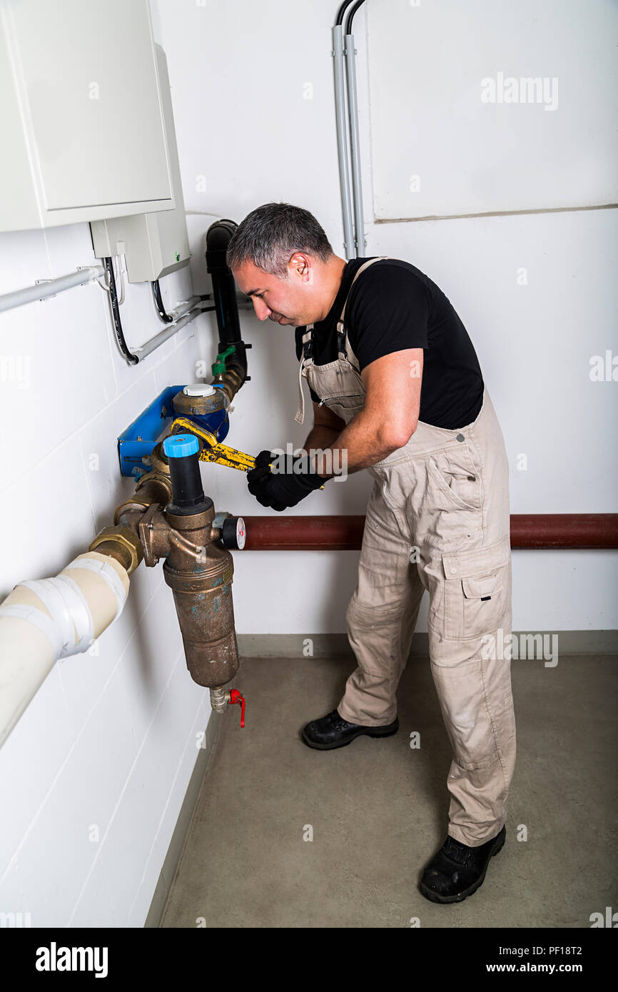 Plumber repairing metallic water pipes with wrench Stock Photo - Alamy