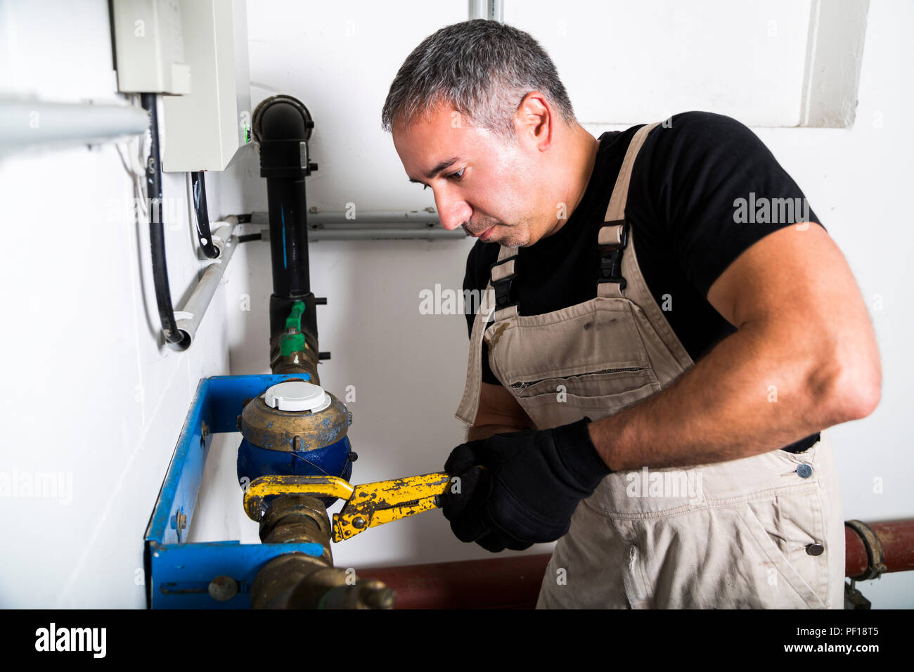Plumber repairing metallic water pipes with wrench Stock Photo - Alamy