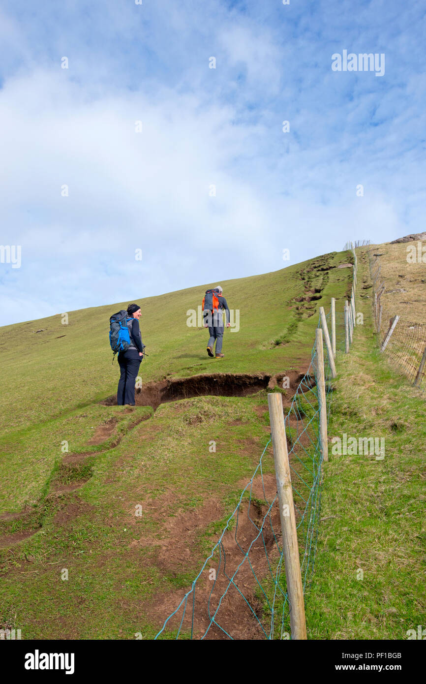Hikers on steep path on cliffs, Gjogv village Eysturoy island, Faroe ...