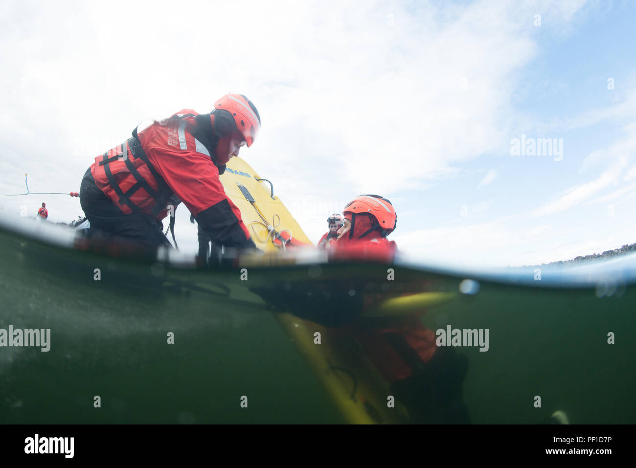 Petty Officer 3rd Class Ryan Rusnak uses an ice rescue board to pull a ...