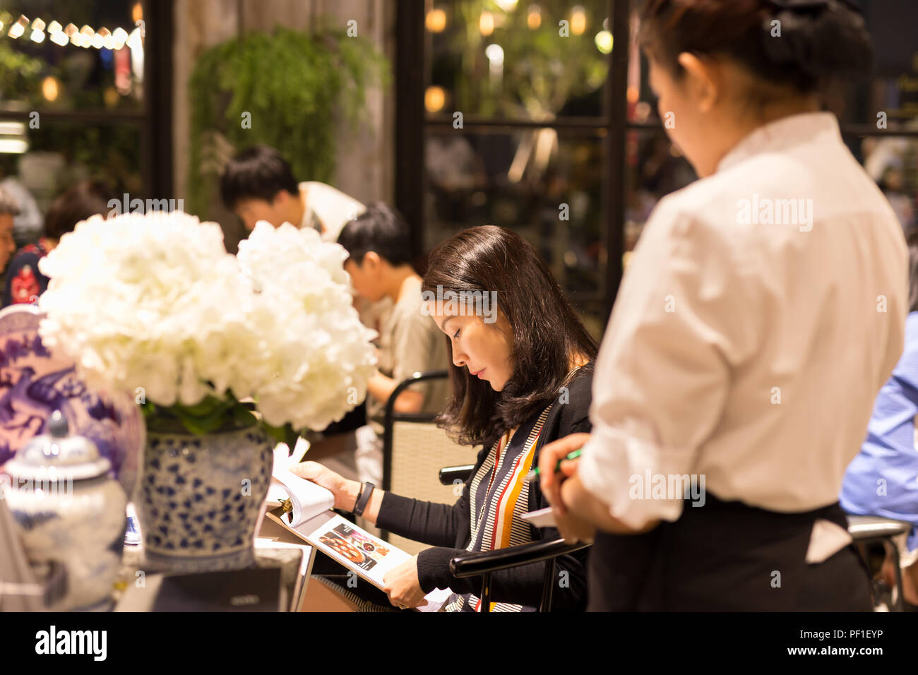 Woman customer looking menu waitress taking order in restaurant Stock ...