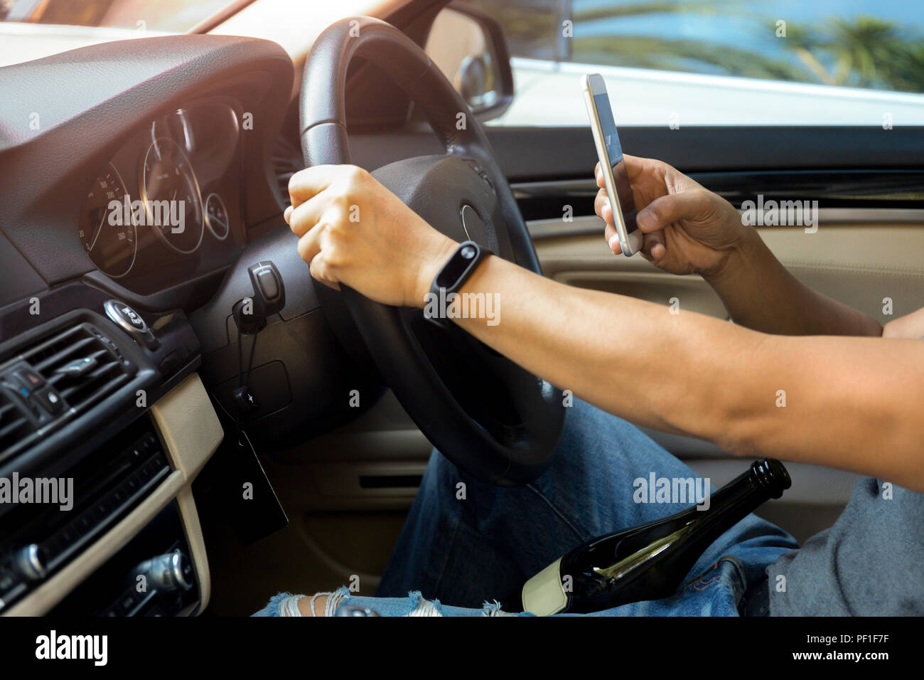 Man using phone while driving the car with bottle wine on hie la Stock ...