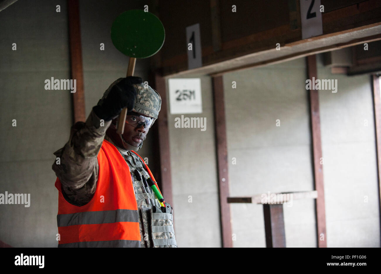 U.S. Army Sgt. Hedge, a range safety officer, signals that shooters are ...