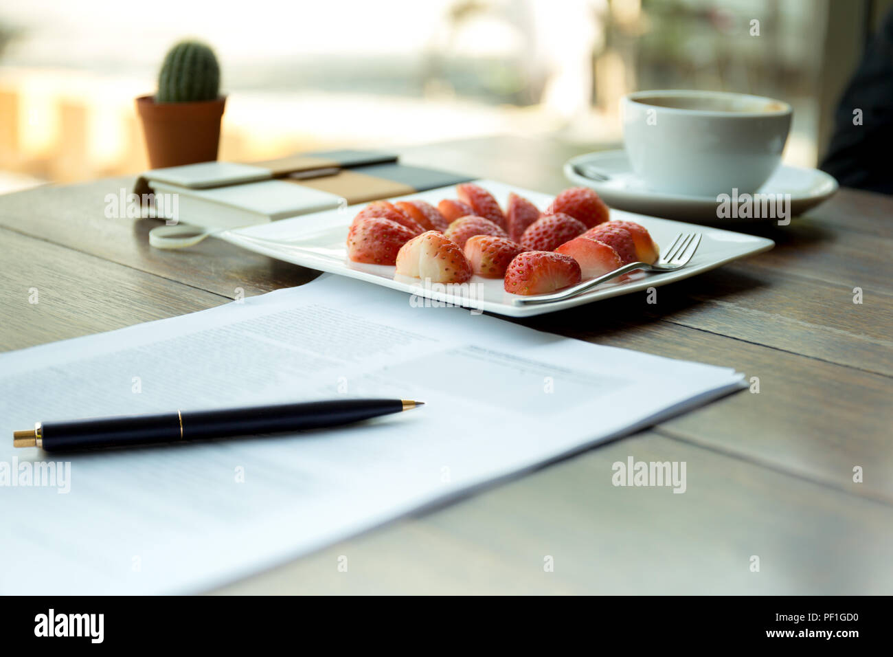 Fresh strawberry with pen and paperwork and coffee cup Stock Photo - Alamy