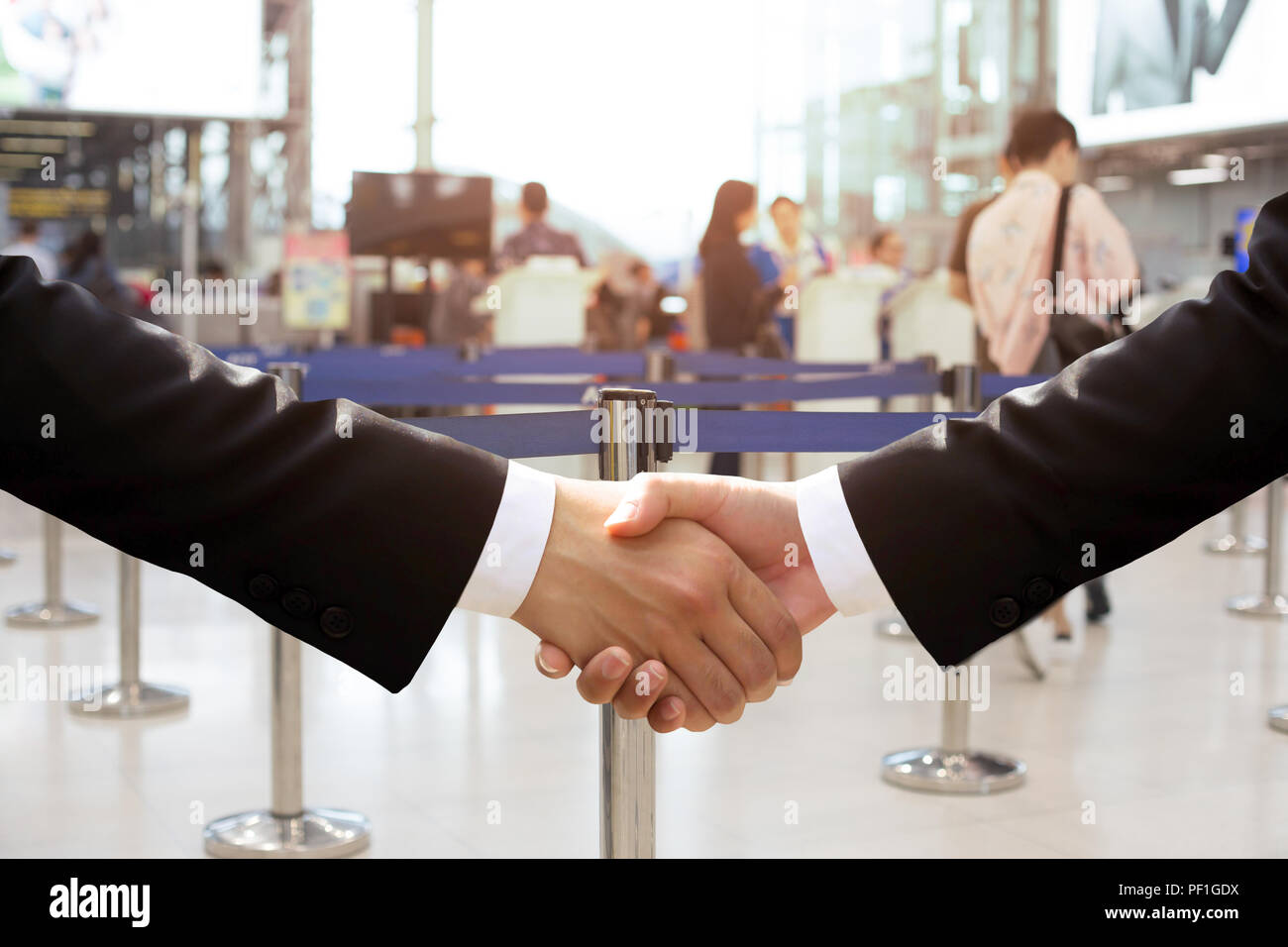 Business hand shake in airport building Stock Photo - Alamy