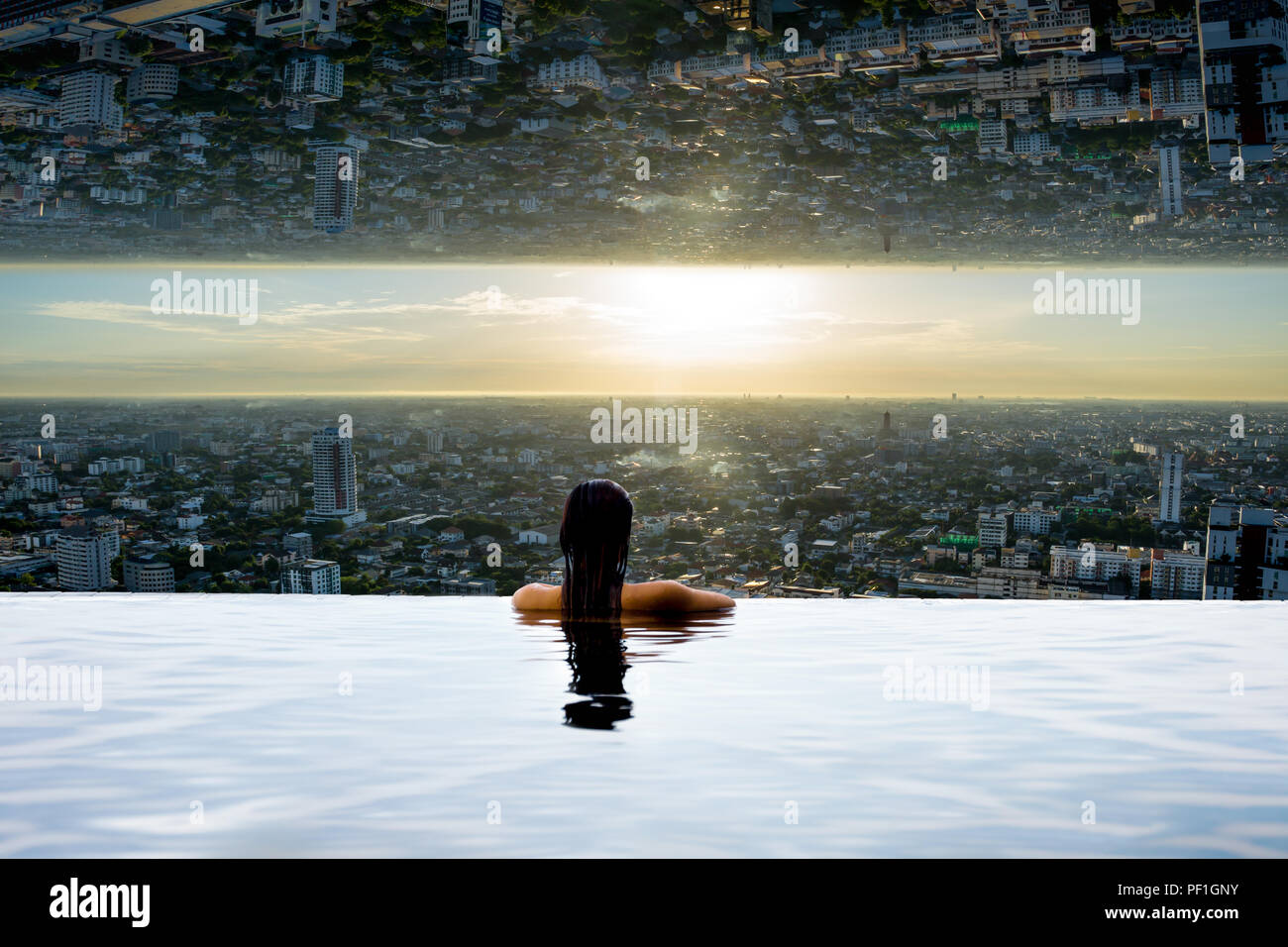 Woman in swimming pool looking at city upside down Stock Photo - Alamy