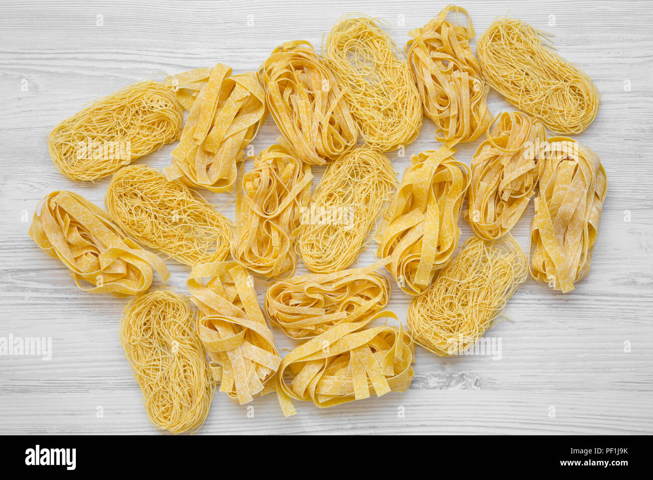 Set of various uncooked pasta on white wooden table, top view. From ...