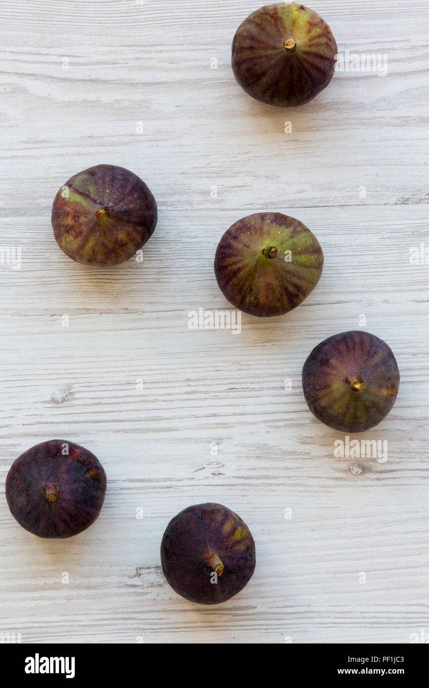 Top view fresh figs on white wooden background. From above, overhead ...