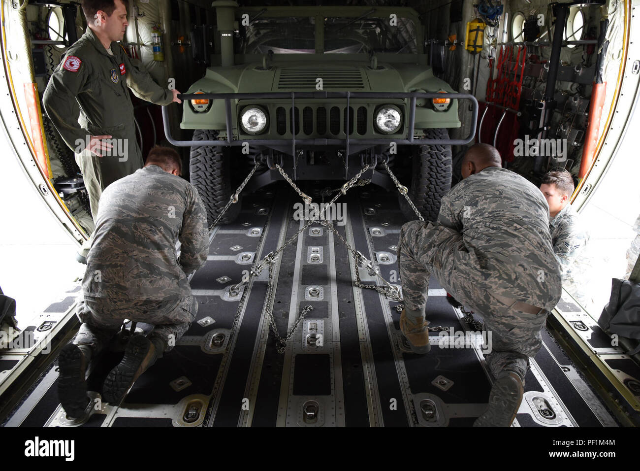 Members of the 403rd Aerial Port Squadron secure a Humvee to the floor ...