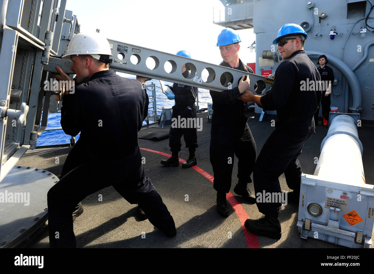 Sailors assigned to the C5I department attach a missile loader into the ...