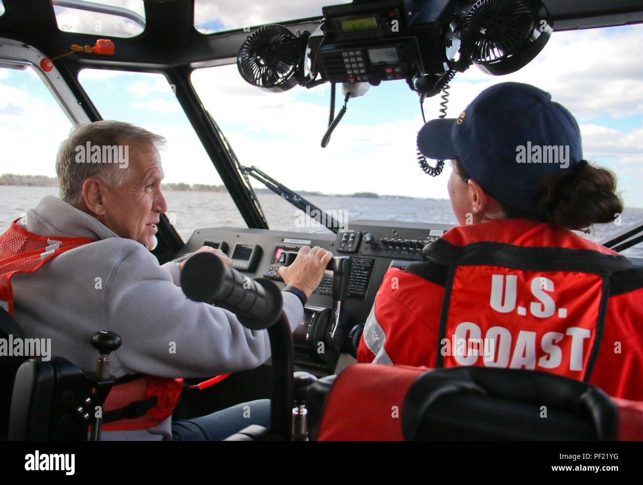 North Carolina Sen. Thom Tillis (left) mans the helm of a Coast Guard ...