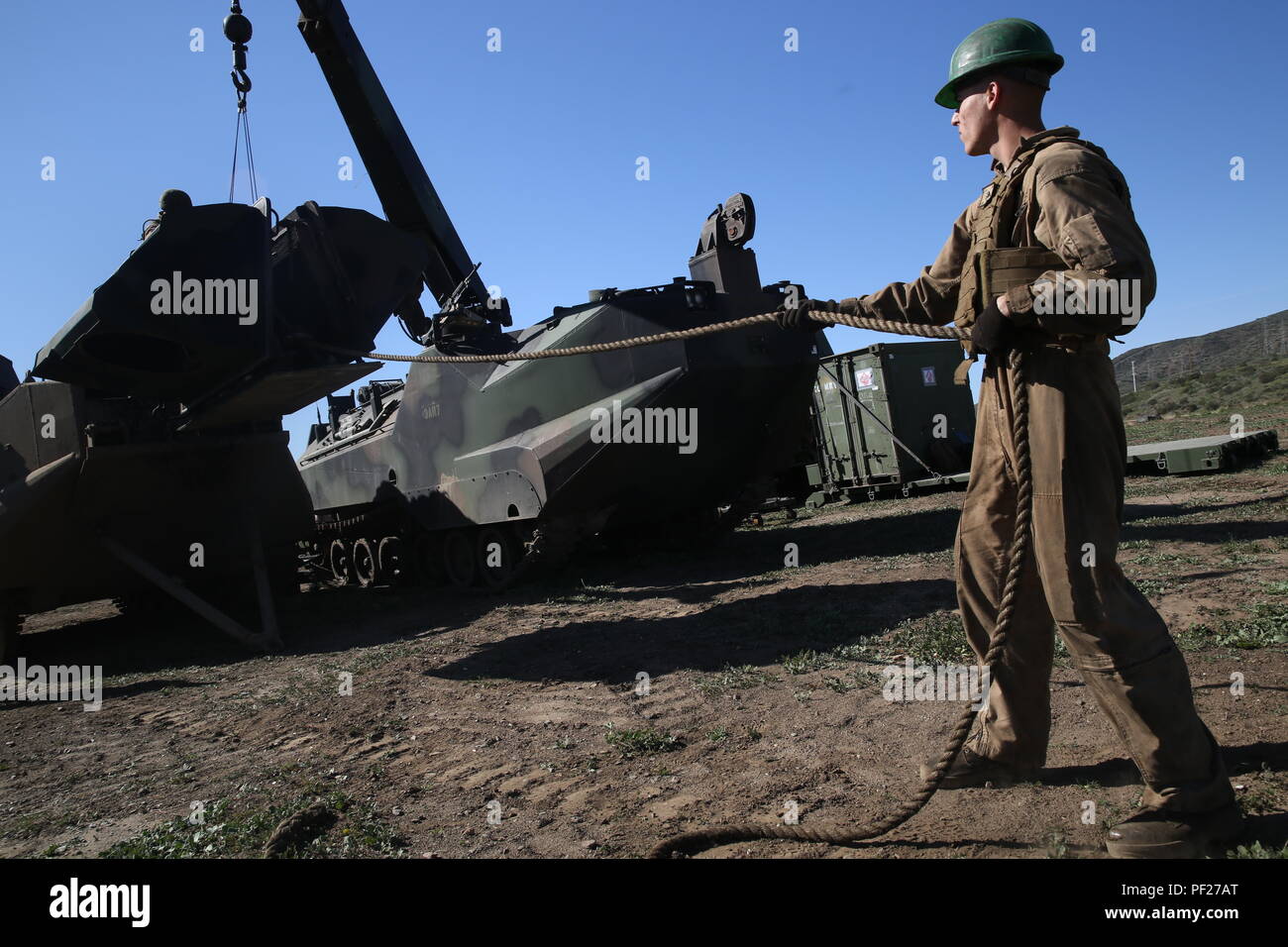 A Marine removes a heavily armored engine cover from an Amphibious ...