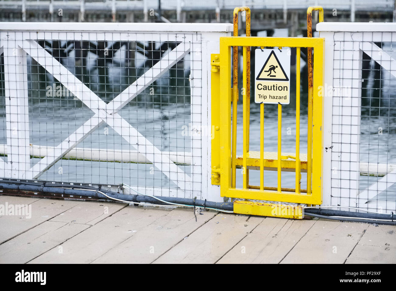 Trip hazard caution sign on ferry ship yellow gate Stock Photo - Alamy