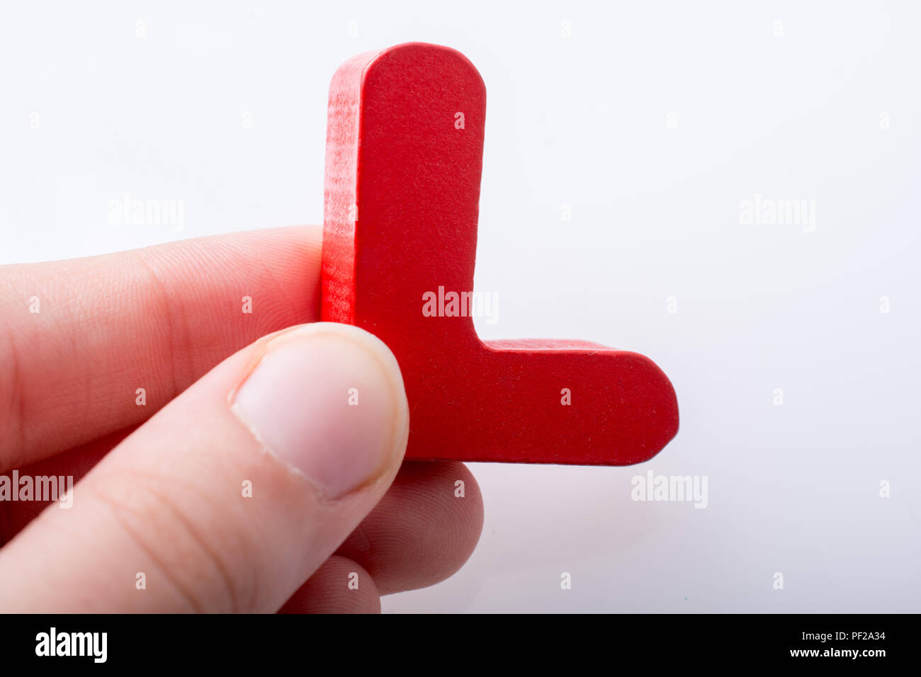 Hand holding letter cube L of made of wood Stock Photo - Alamy