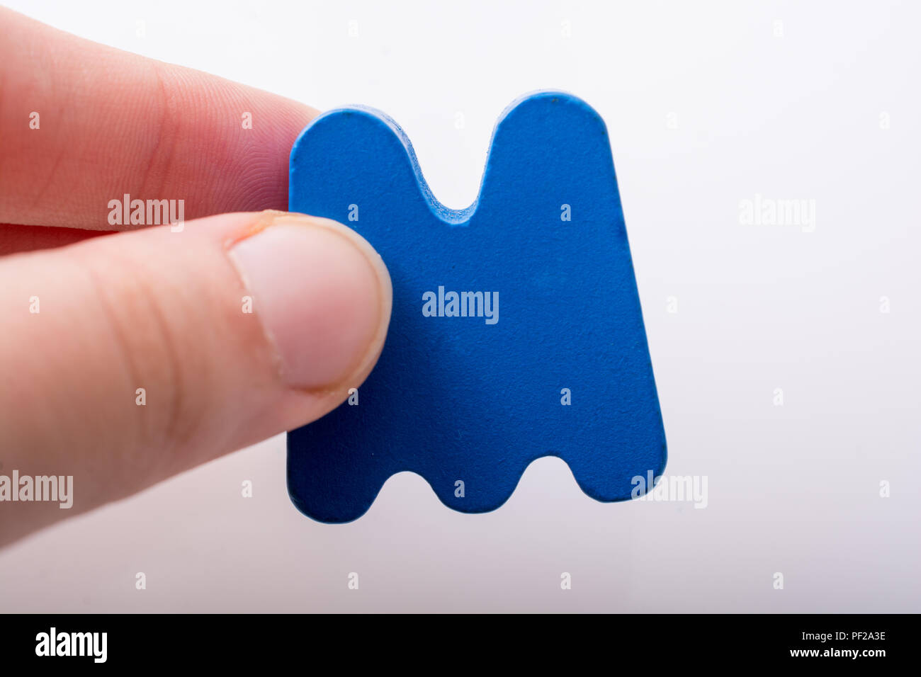 Hand holding letter cube M of made of wood Stock Photo - Alamy