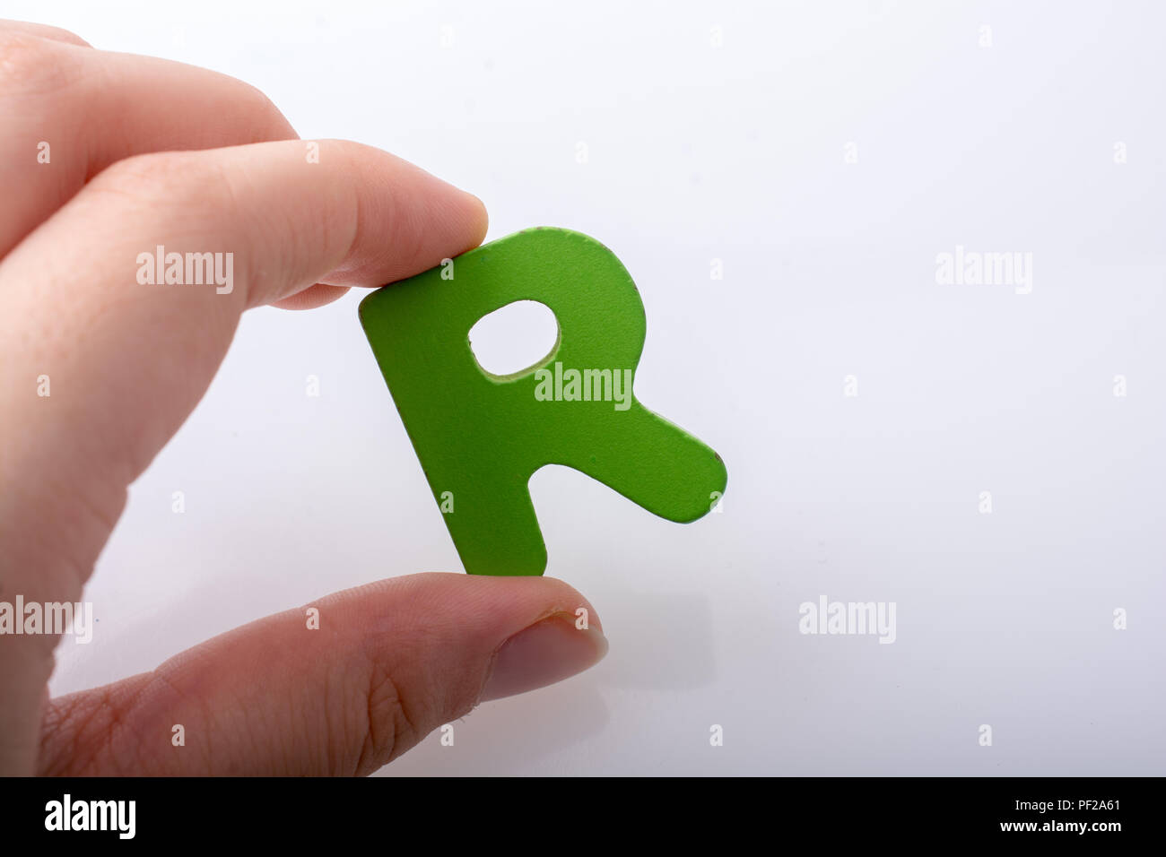 Hand holding letter cube R of made of wood Stock Photo - Alamy