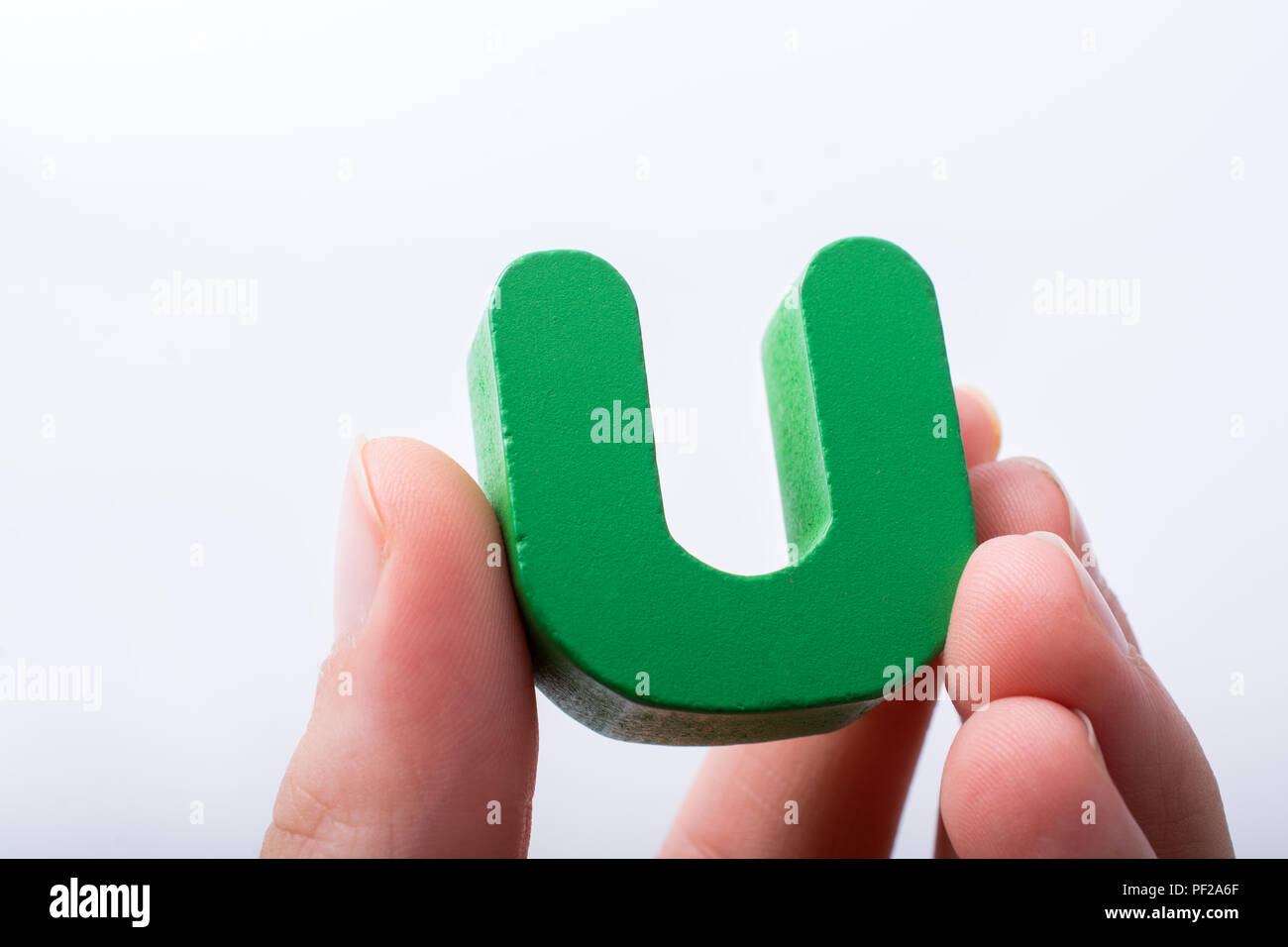 Hand holding letter cube U of made of wood Stock Photo - Alamy