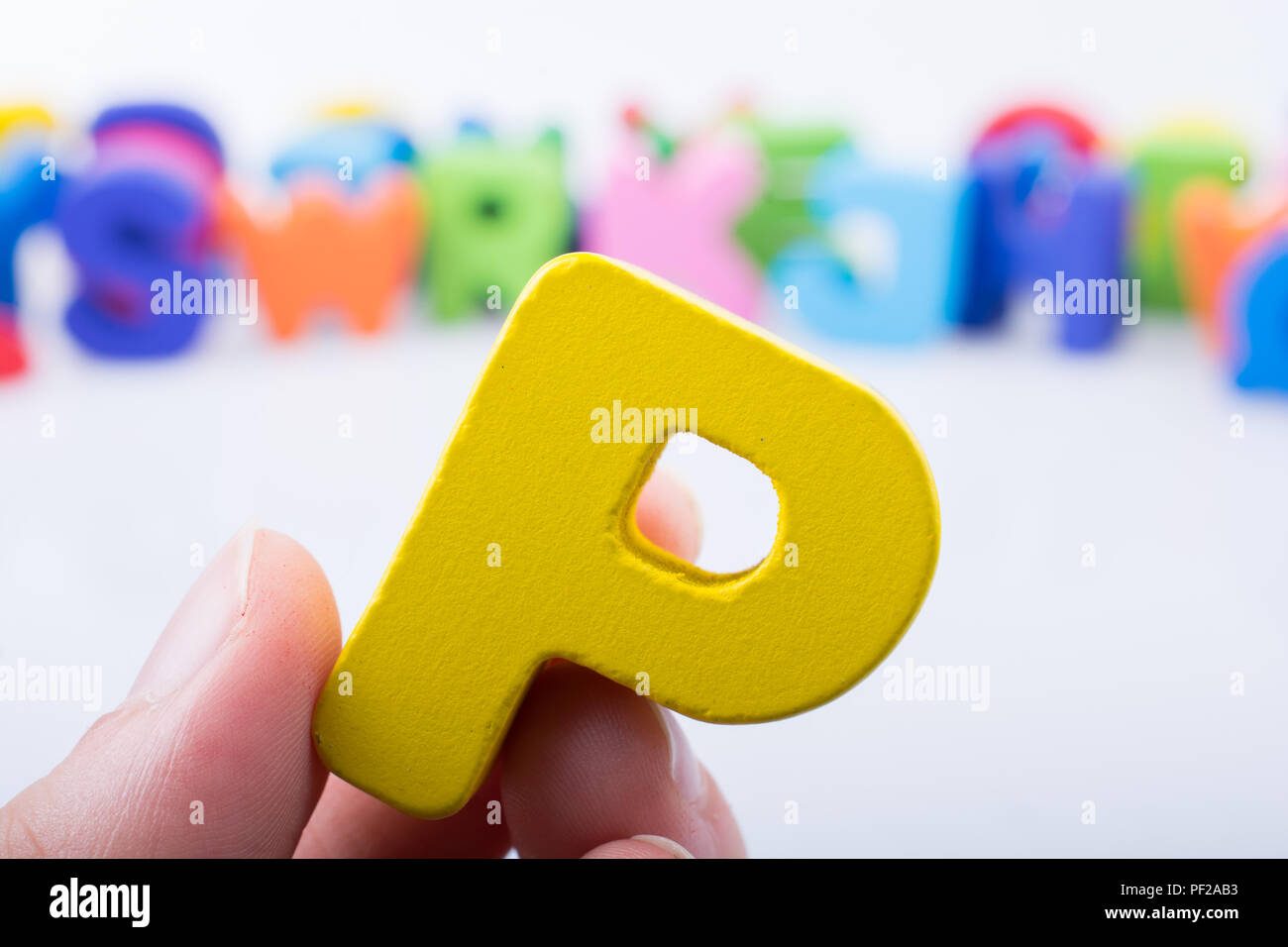 Hand holding letter cube P of made of wood Stock Photo - Alamy