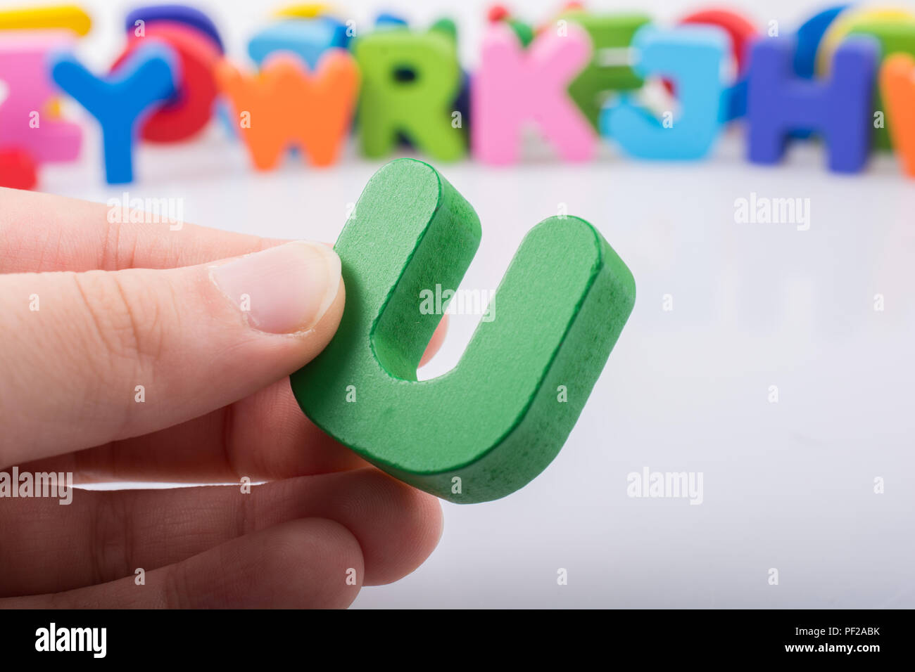 Hand holding letter cube U of made of wood Stock Photo - Alamy