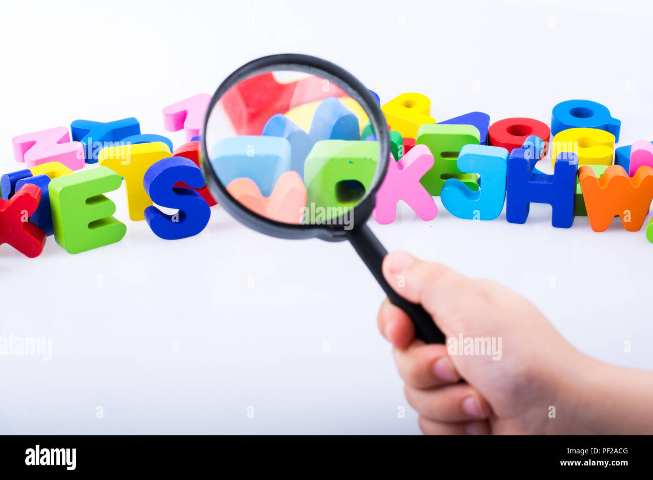 Hand holding magnifying glass over wooden alphabet letters Stock Photo ...