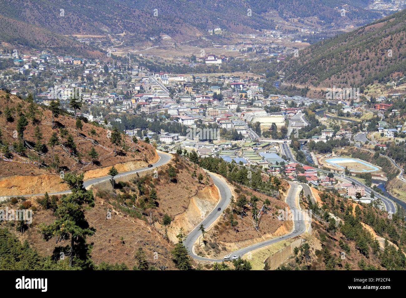 Winding or curved asphalt road on the hill with view of Thimphu city ...