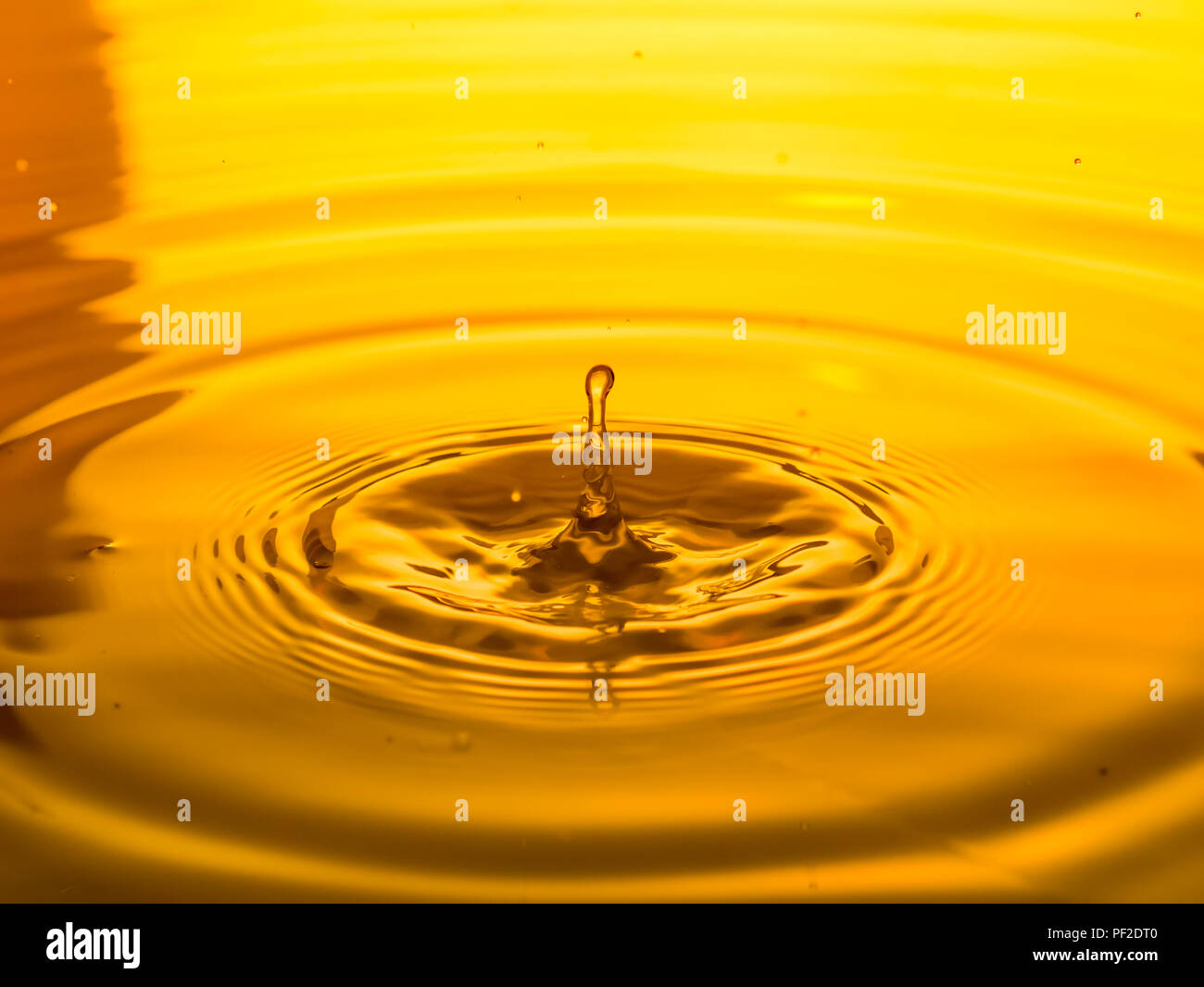 close up of a drop oil on a yellow background Stock Photo - Alamy