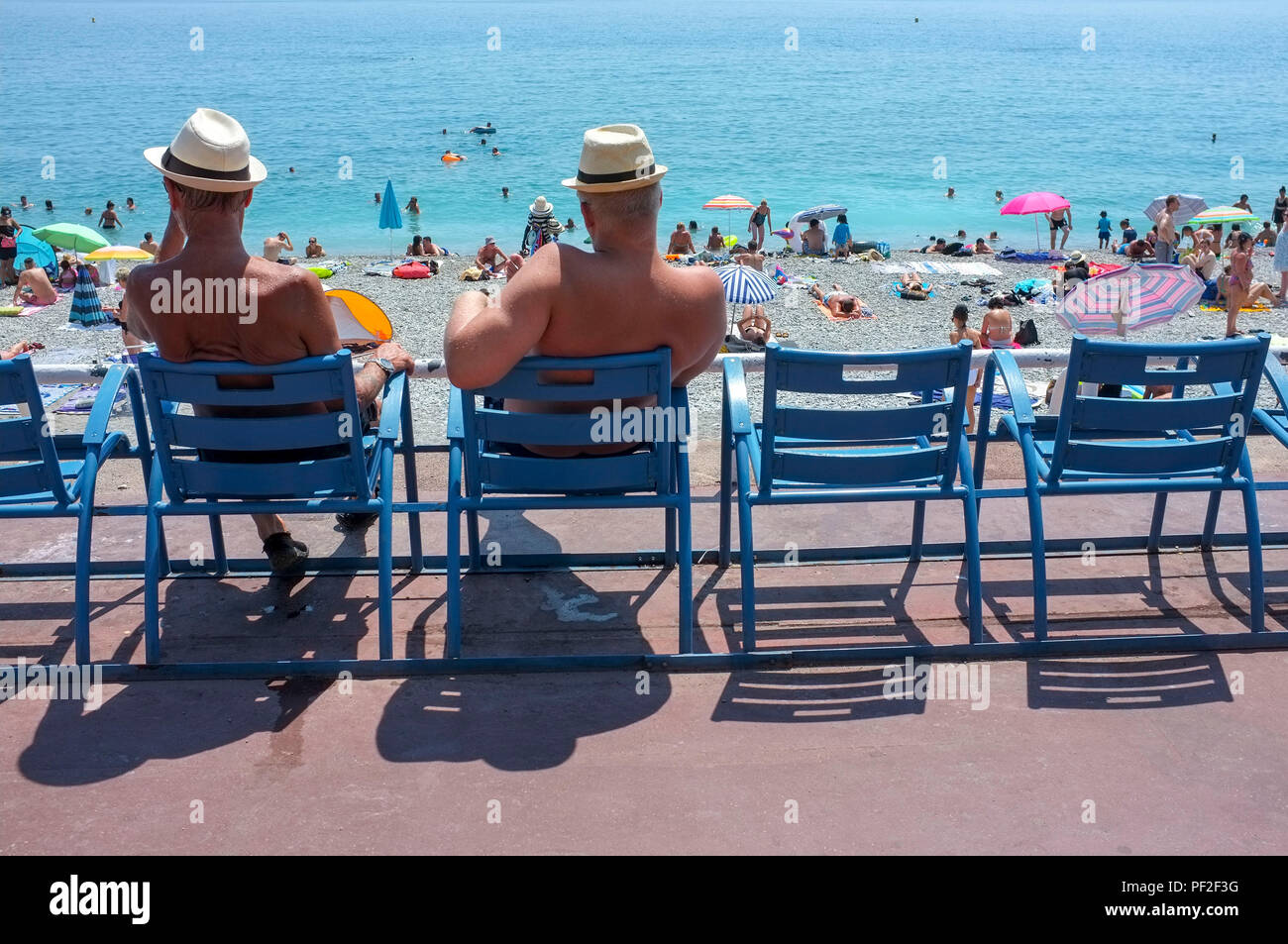 Two men sit on the Blue Chairs on the Promenade Des Anglais in Nice ...