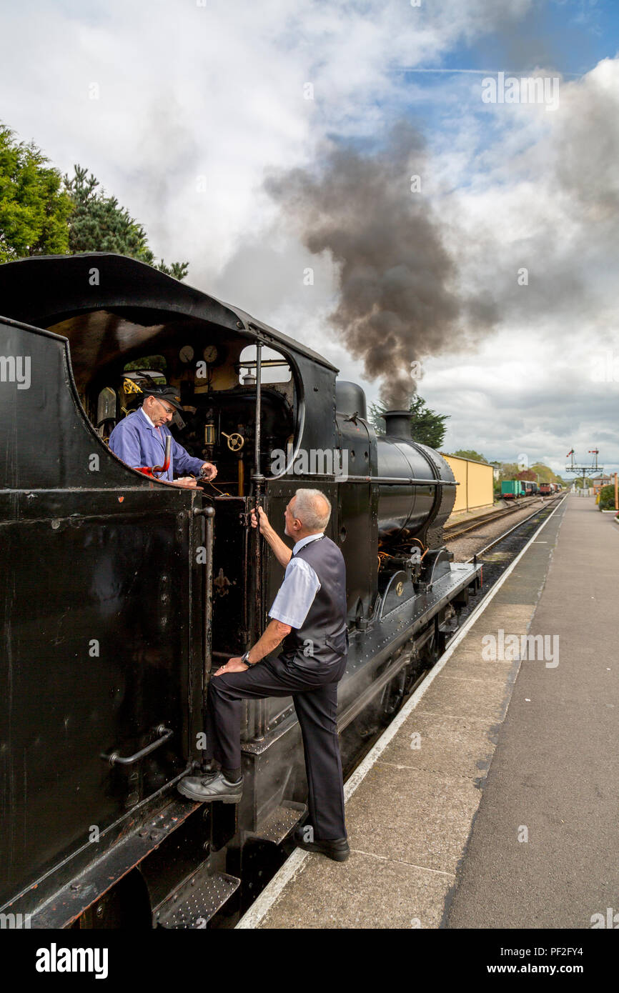 The driver and guard of a steam train chat prior to departure from ...