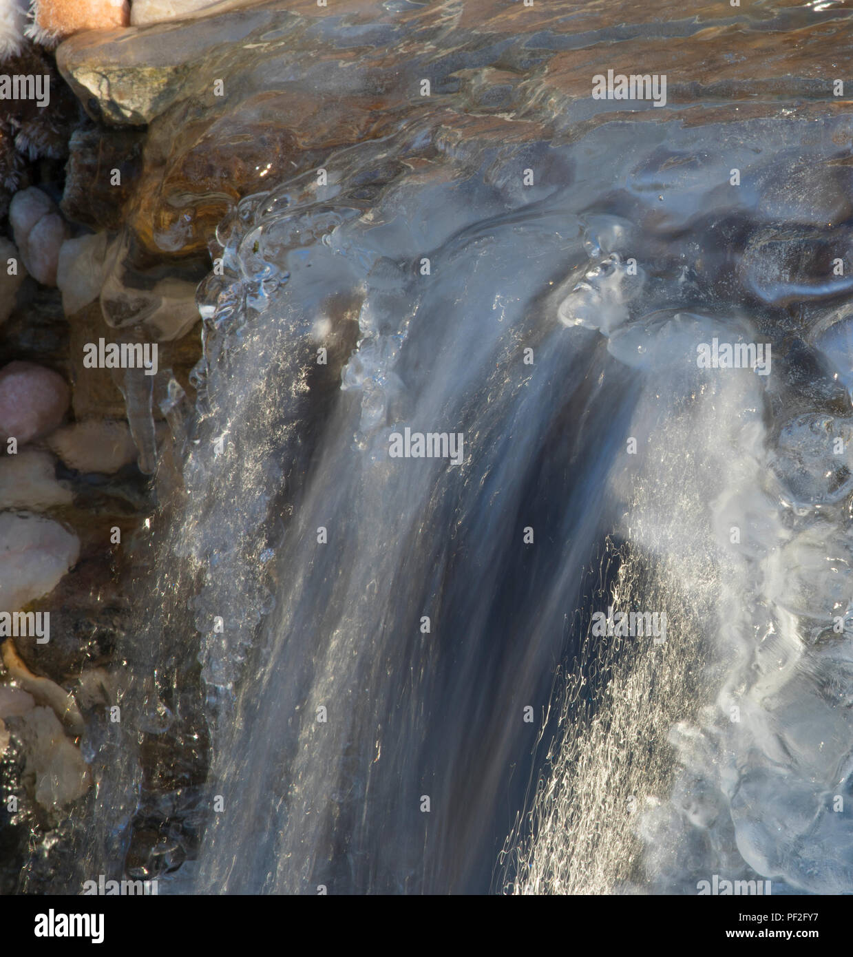 Small waterfall with lots of ice and water still flowing Stock Photo ...