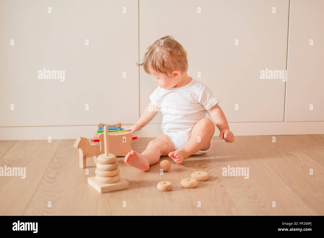 Cute little baby boy playing with stacking rings in the room Stock ...