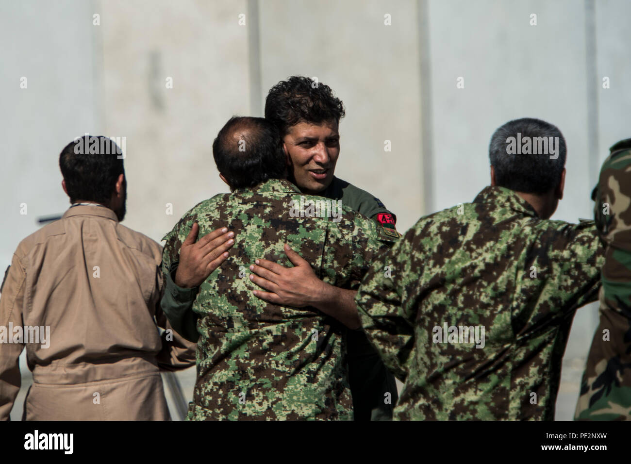 An Afghan air force pilot hugs an Afghan National Army soldier during ...