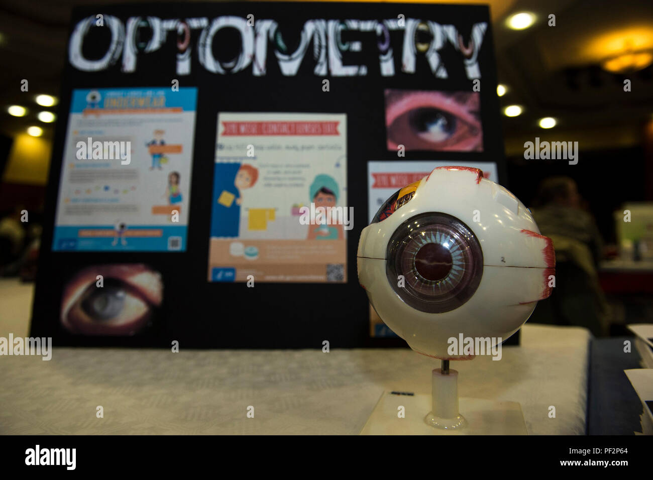 A model eye is on display in front of an optometry information board at ...