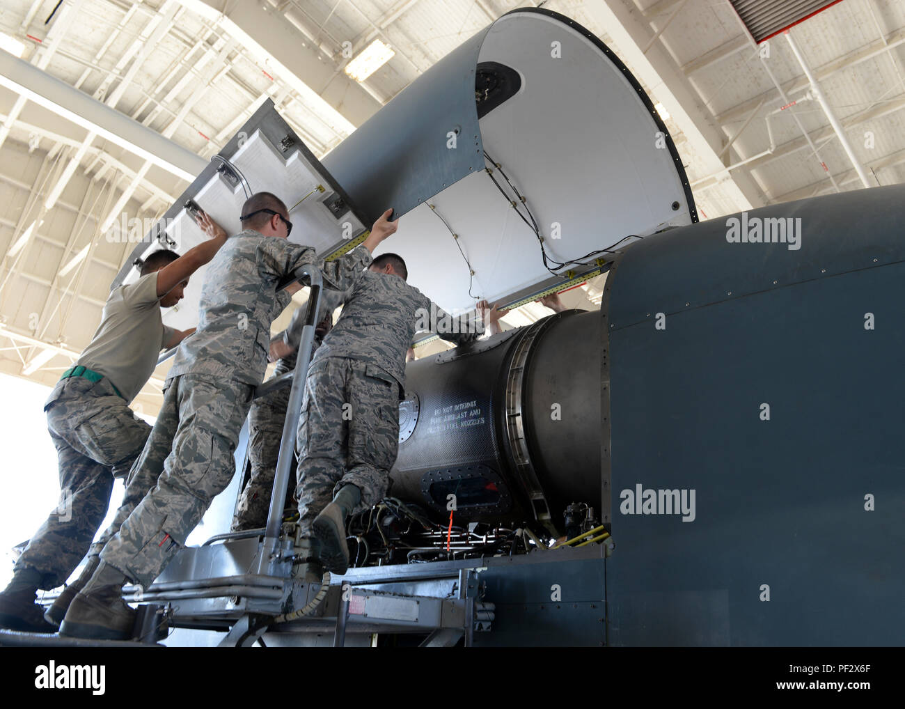 Airmen from the 12th Aircraft Maintenance Unit installs an engine cover ...